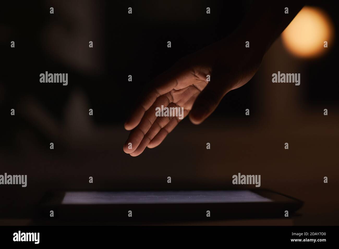 Minimal close up of male hand reaching for digital tablet with lit ...
