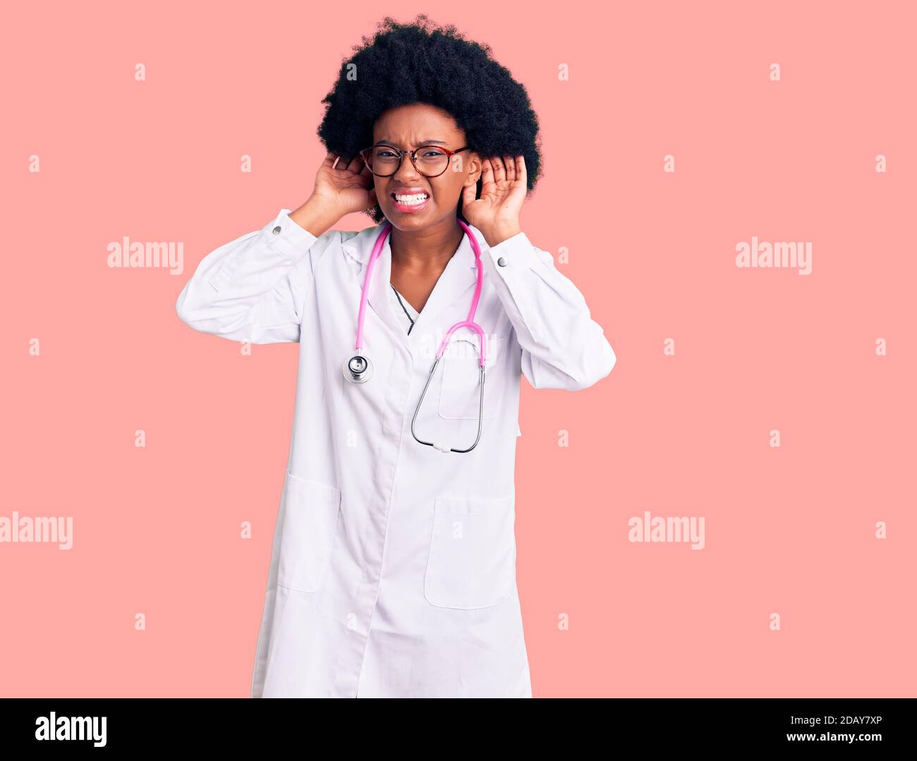 Young african american woman wearing doctor coat and stethoscope trying ...