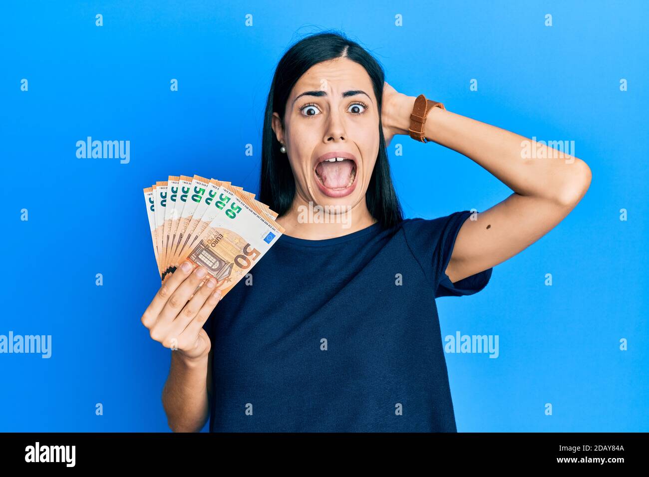 Beautiful young woman holding bunch of 50 euro banknotes crazy and ...
