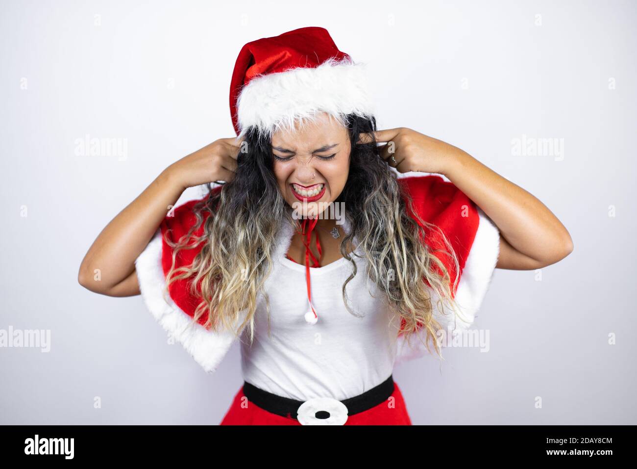 Young beautiful woman wearing a Santa Claus costume over white ...