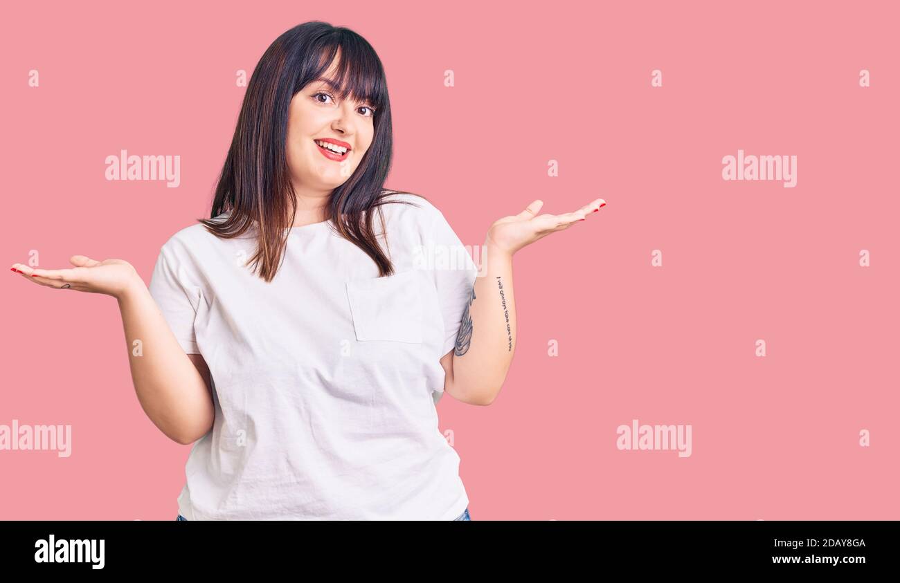 Young plus size woman wearing casual clothes smiling showing both hands ...