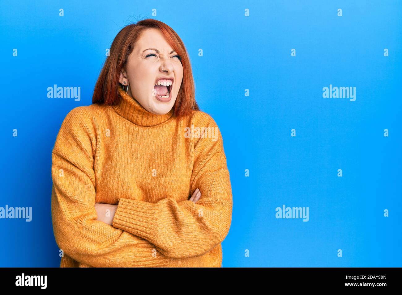 Beautiful redhead woman with arms crossed gesture angry and mad ...