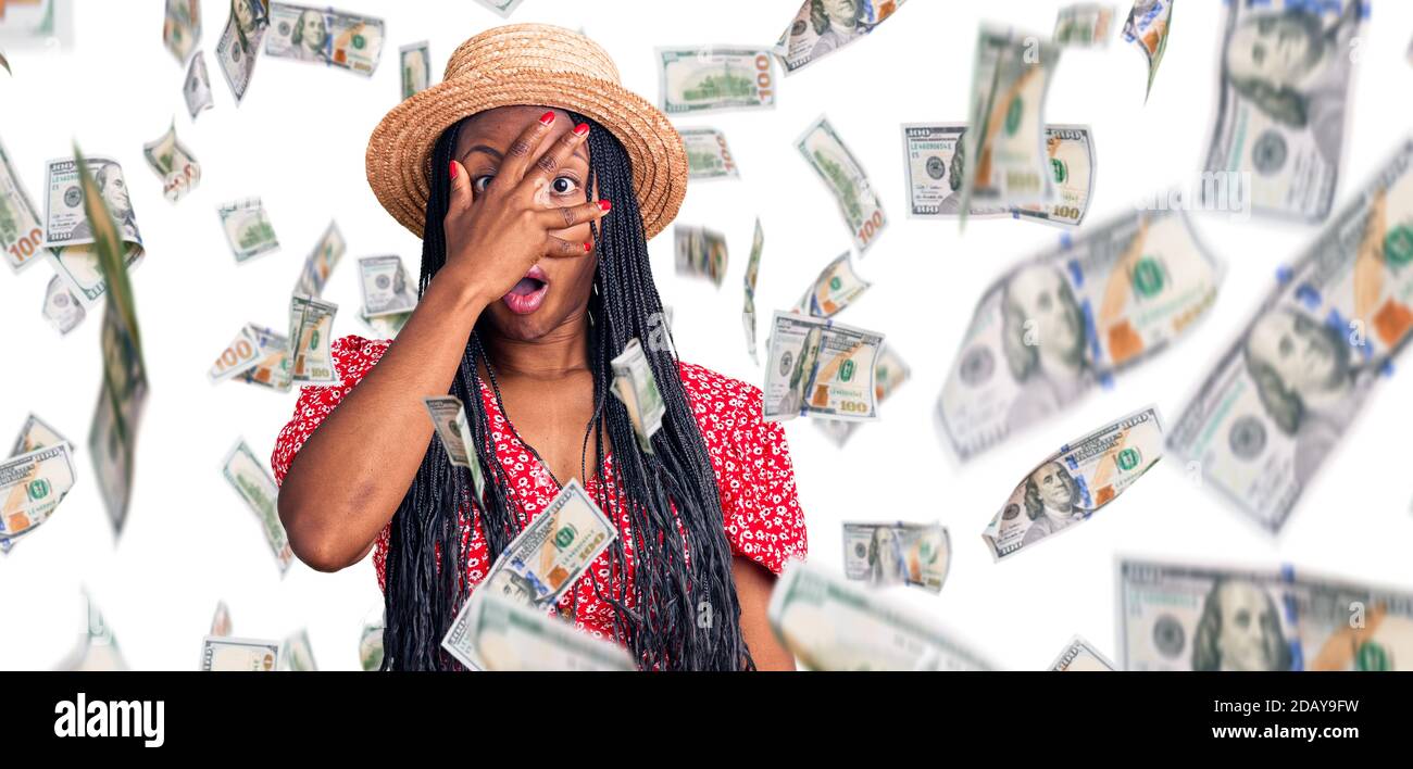 Young african american woman wearing summer hat peeking in shock ...