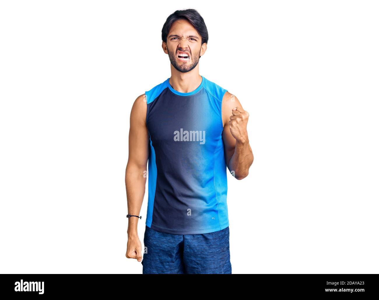 Handsome hispanic man wearing sportswear angry and mad raising fist ...
