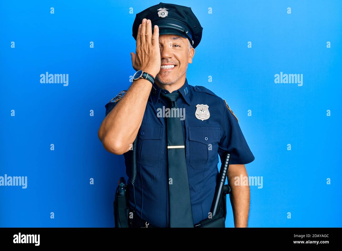 Handsome middle age mature man wearing police uniform covering one eye ...