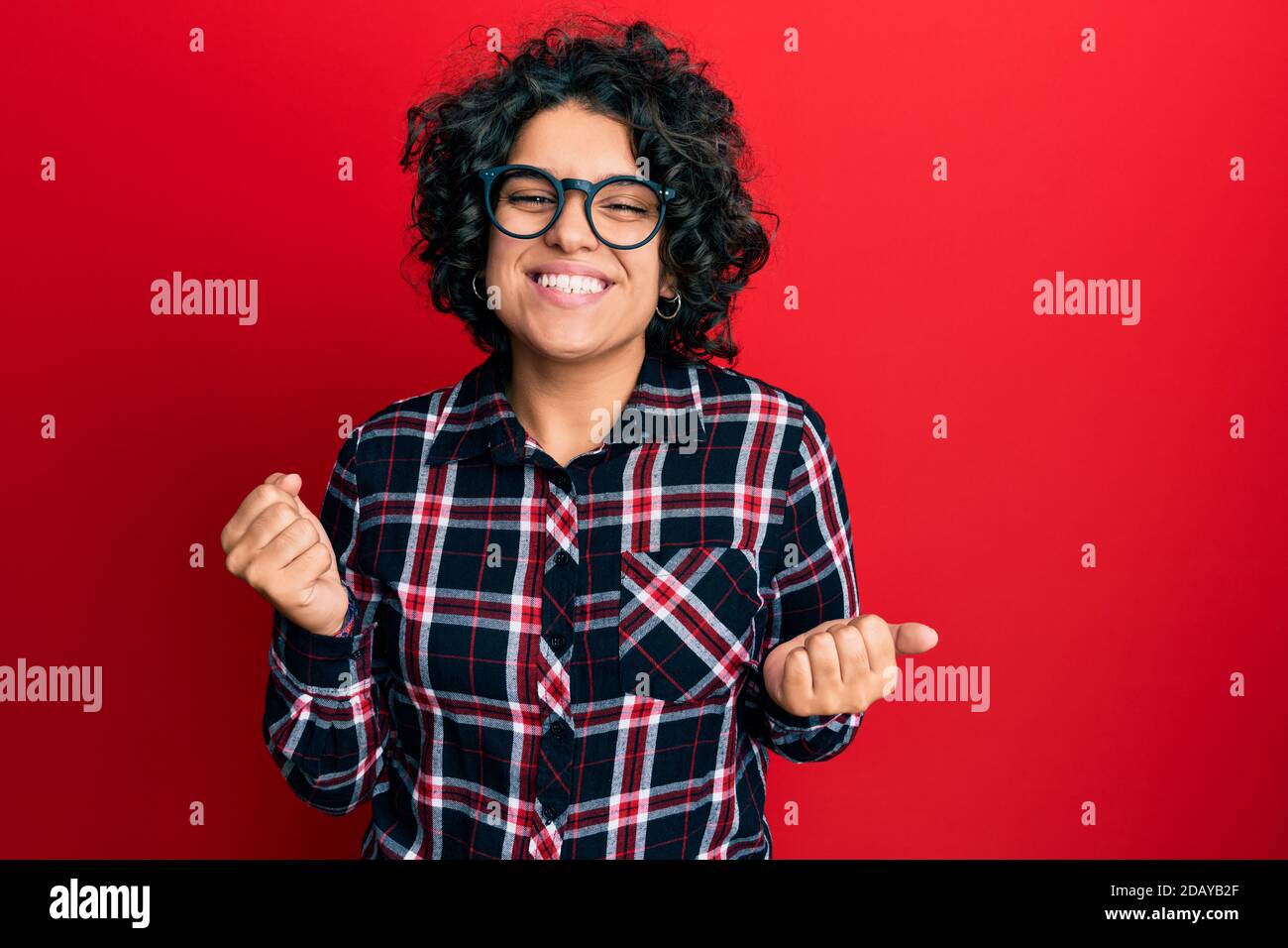 Hispanic woman with curly hair wearing casual clothes and glasses ...