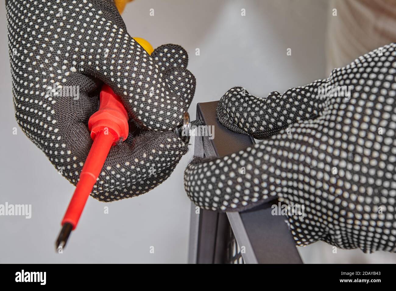 Worker is attaching magnetic lock to metal door of modern TV stand ...