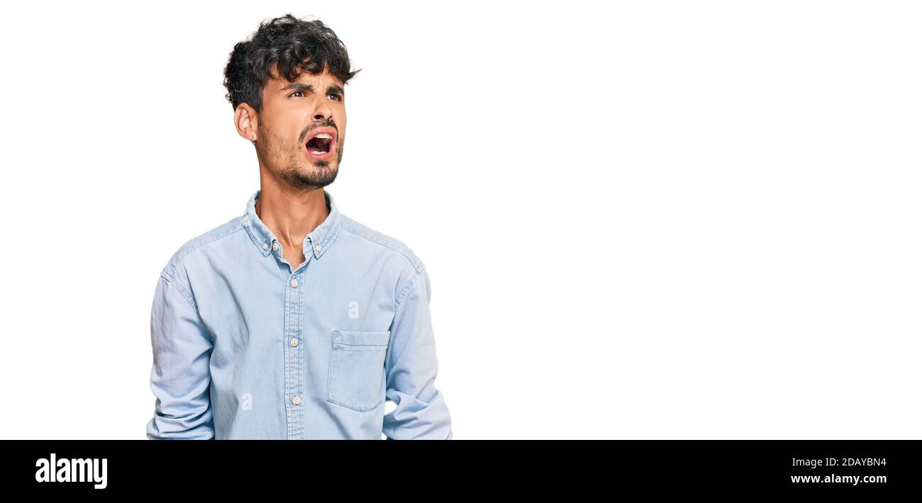 Young hispanic man wearing casual clothes angry and mad screaming ...
