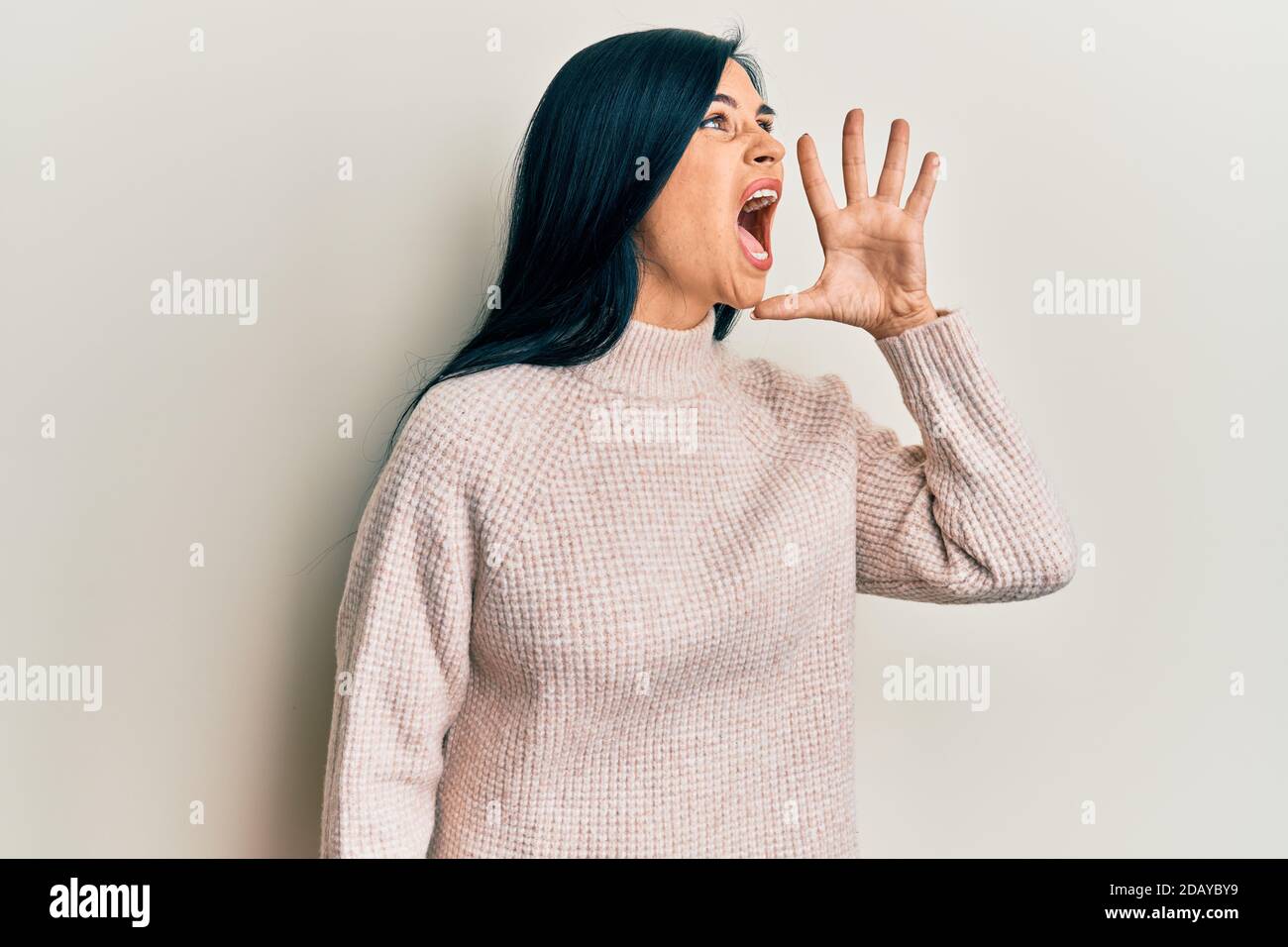 Young caucasian woman wearing casual winter sweater shouting and ...