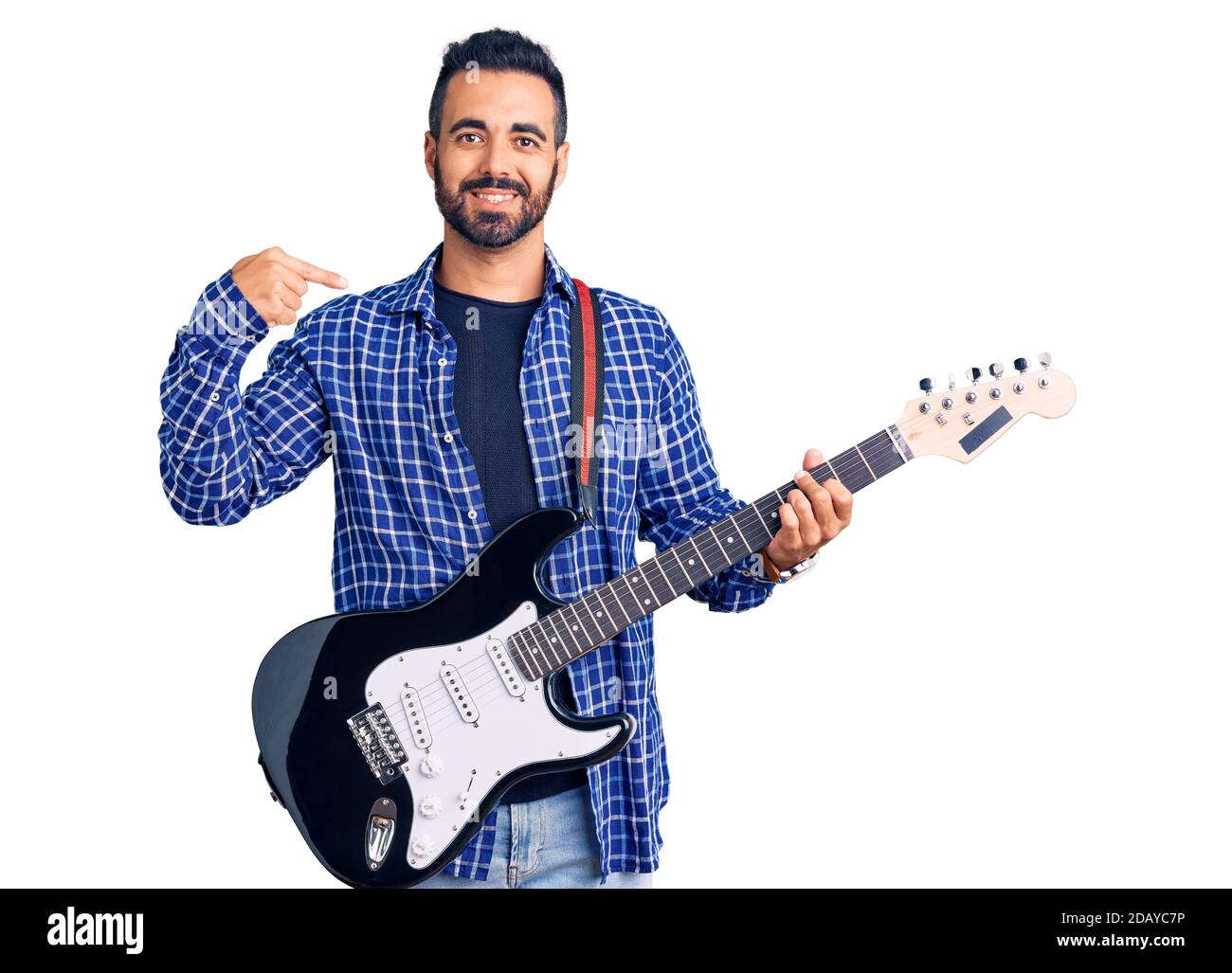 Young hispanic man playing electric guitar pointing finger to one self ...