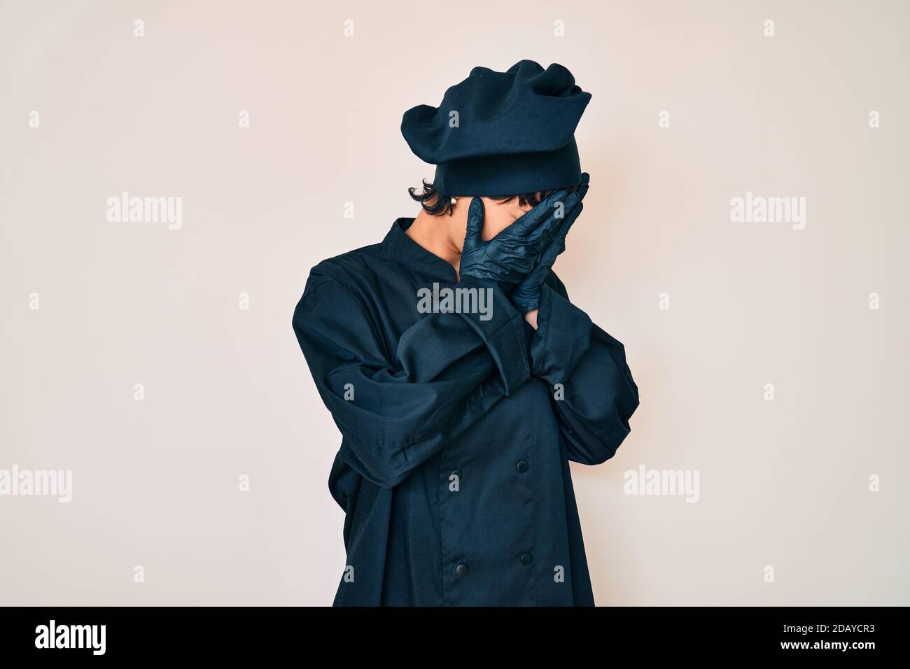 Beautiful brunettte woman wearing professional cook uniform with sad ...