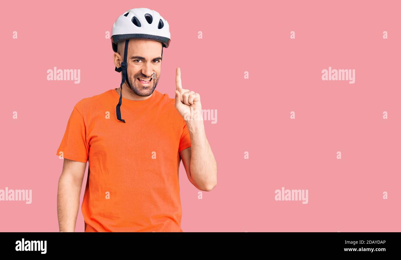 Young Handsome Man Wearing Bike Helmet Pointing Finger Up With