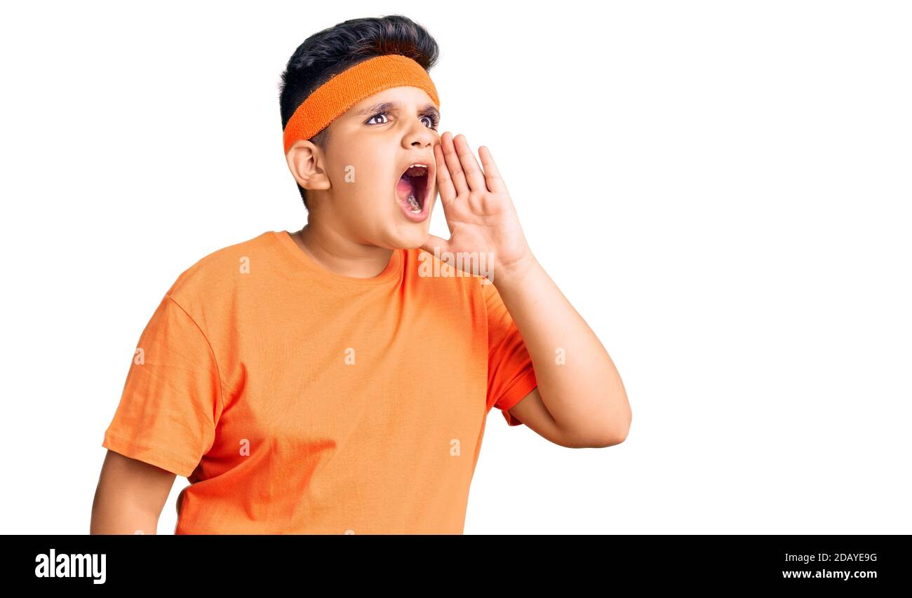 Little boy kid wearing sportswear shouting and screaming loud to side ...