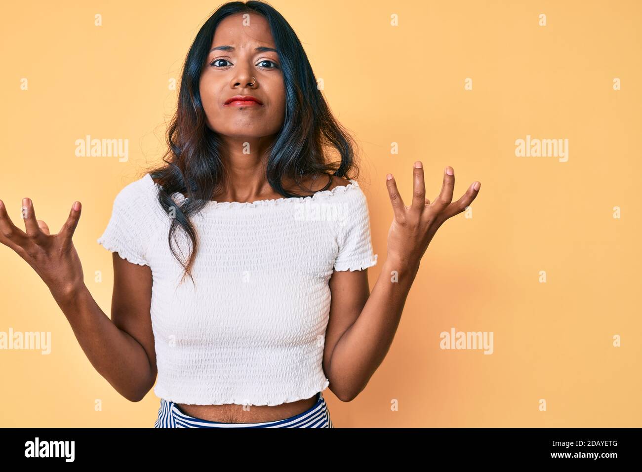 Young indian girl wearing casual clothes crazy and mad shouting and ...