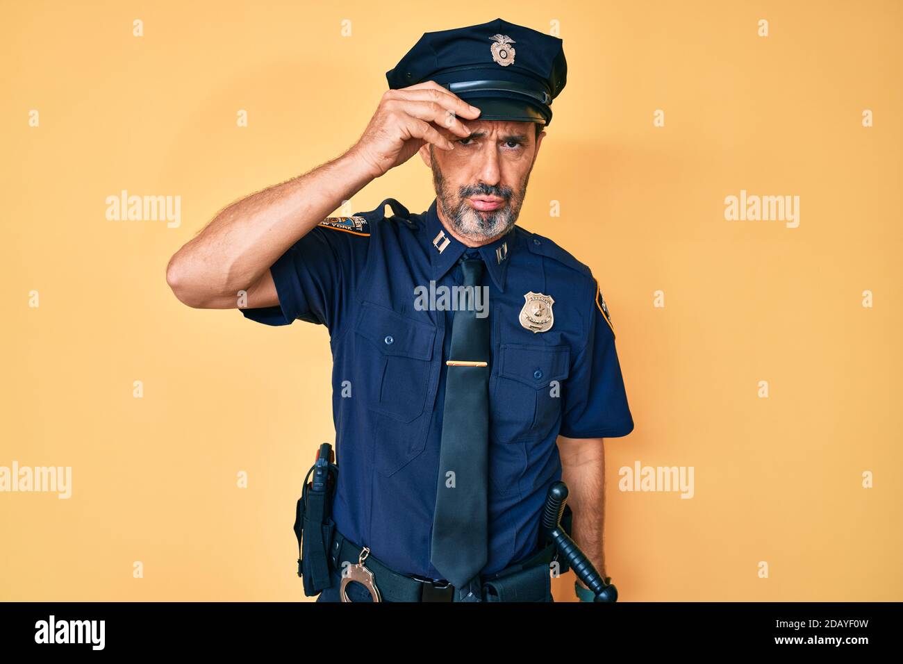 Middle age hispanic man wearing police uniform worried and stressed ...