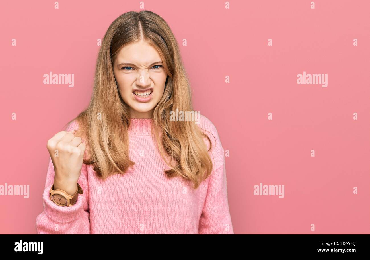 Beautiful young caucasian girl wearing casual winter sweater angry and ...