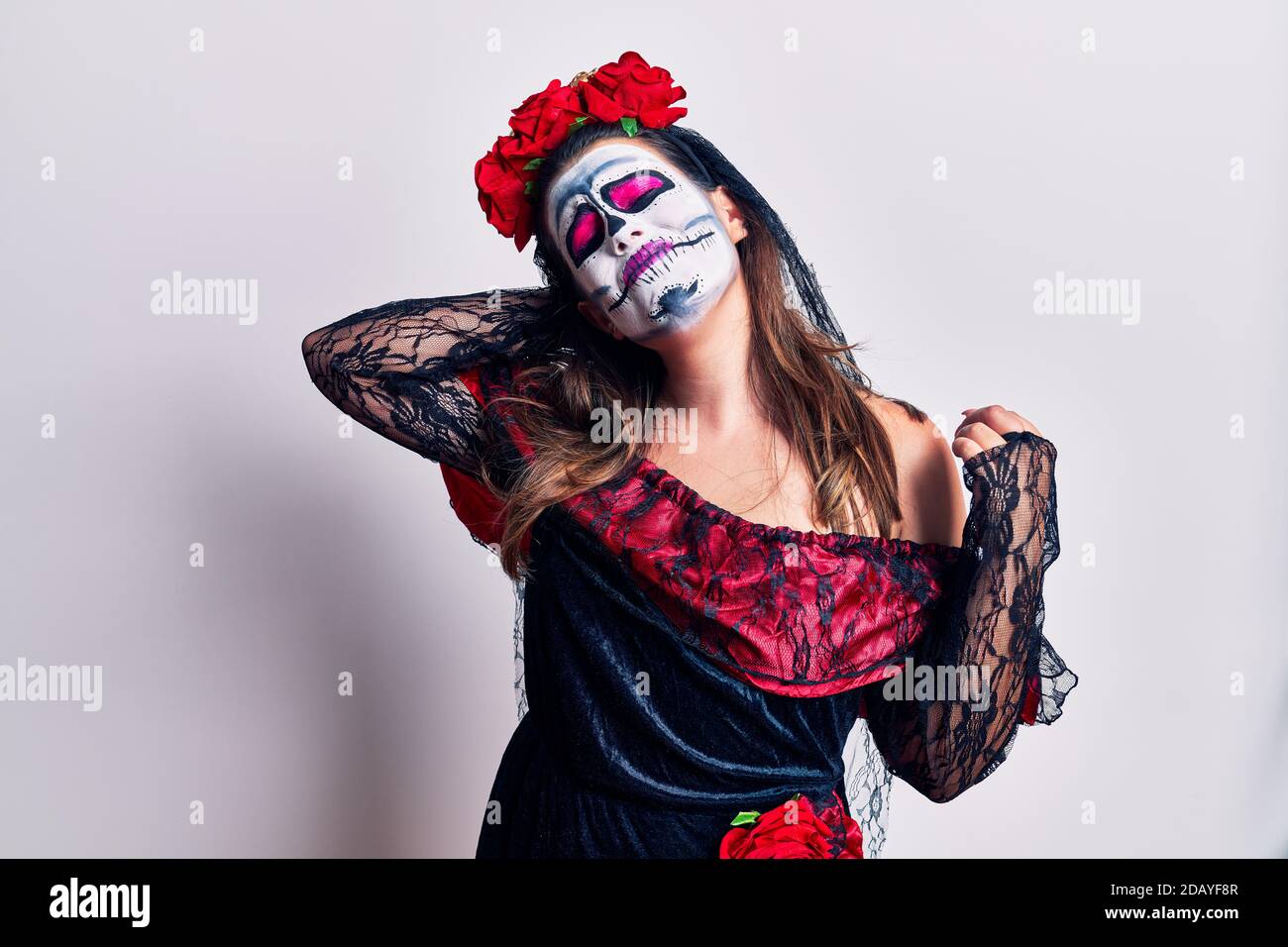 Young woman wearing day of the dead costume over white suffering of ...