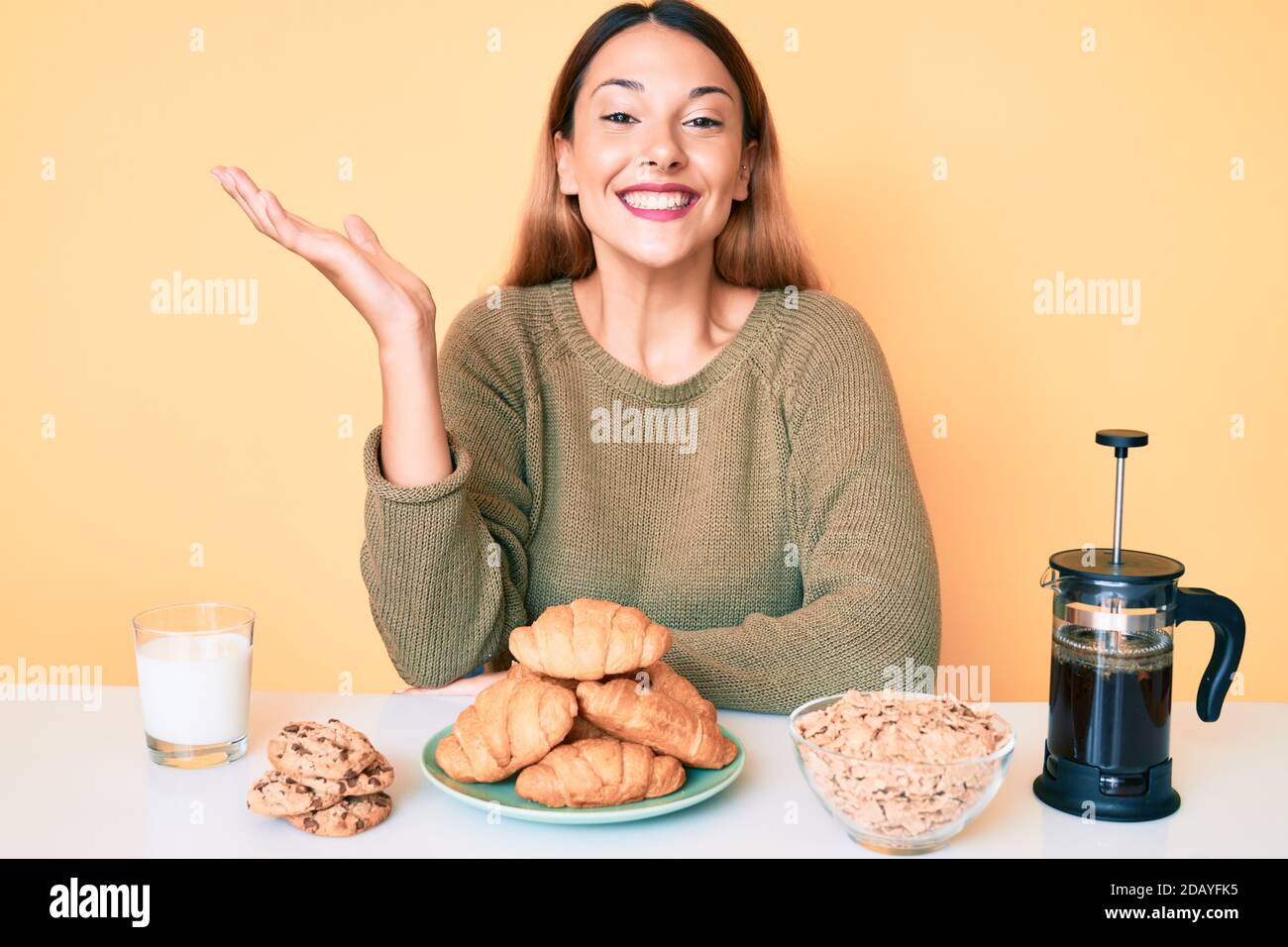 Young brunette woman sitting on the table having breakfast celebrating ...