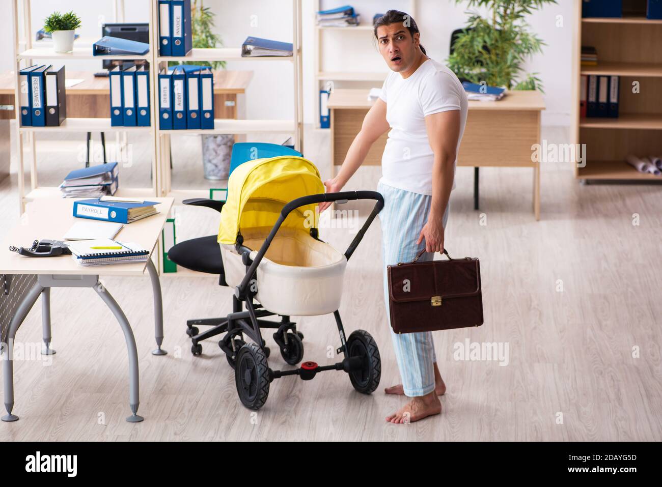 Young employee looking after newborn at workplace Stock Photo - Alamy