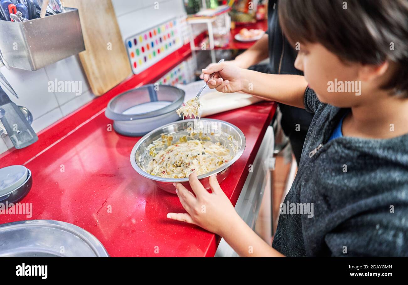 Little boy cooking with his mother in a kitchen under the lights Stock ...