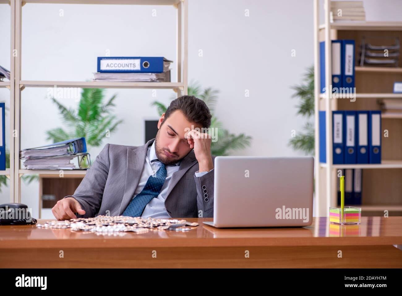 Male sick employee suffering at workplace Stock Photo - Alamy