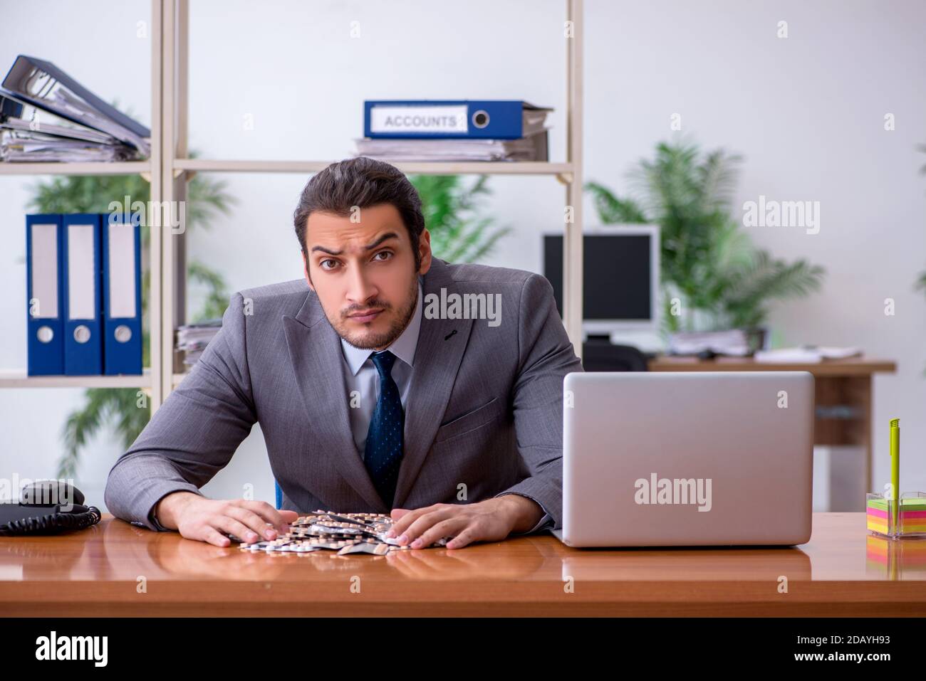 Male sick employee suffering at workplace Stock Photo - Alamy