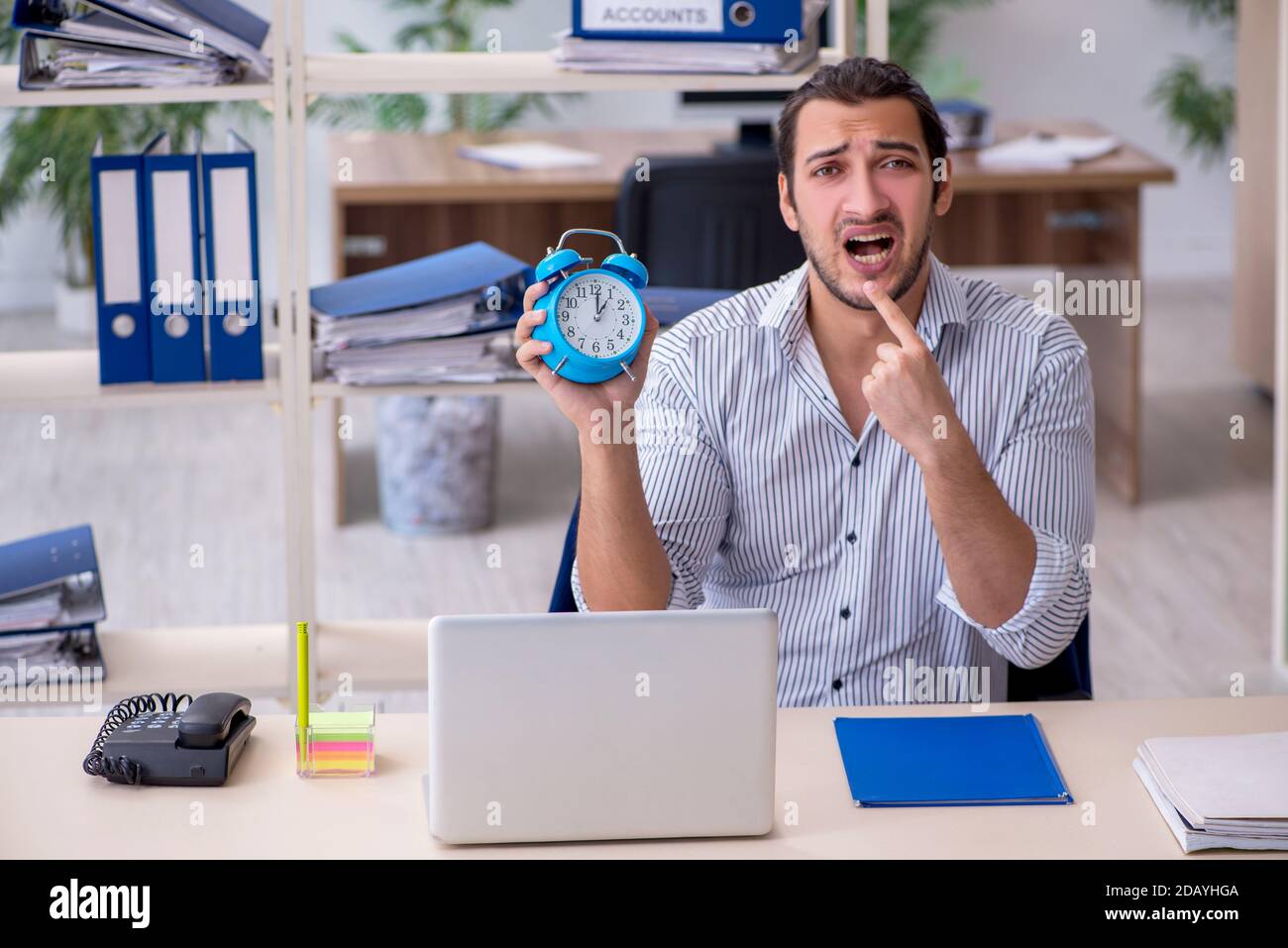 Hungry employee waiting for food in time management concept Stock Photo ...