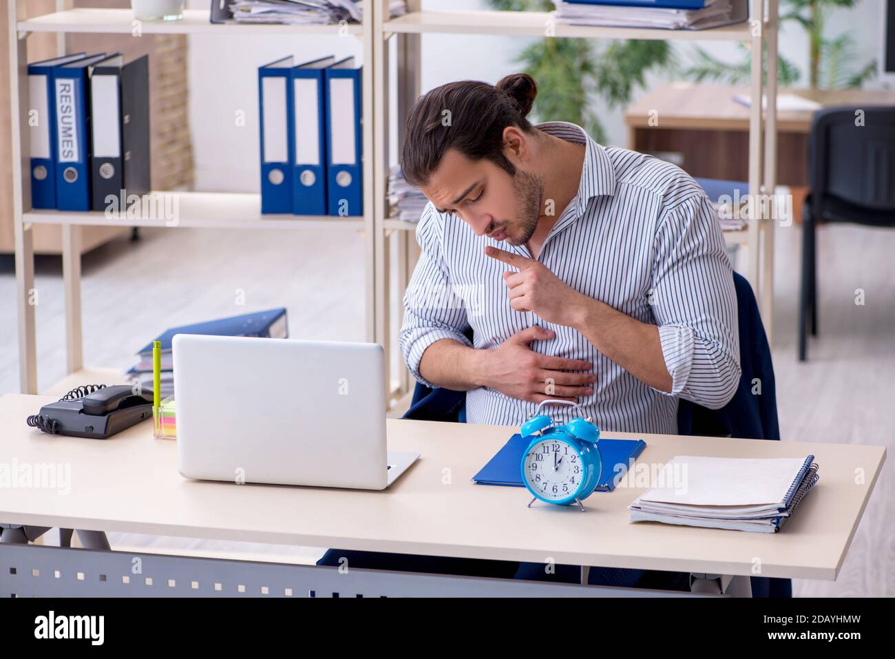 Hungry employee waiting for food in time management concept Stock Photo ...
