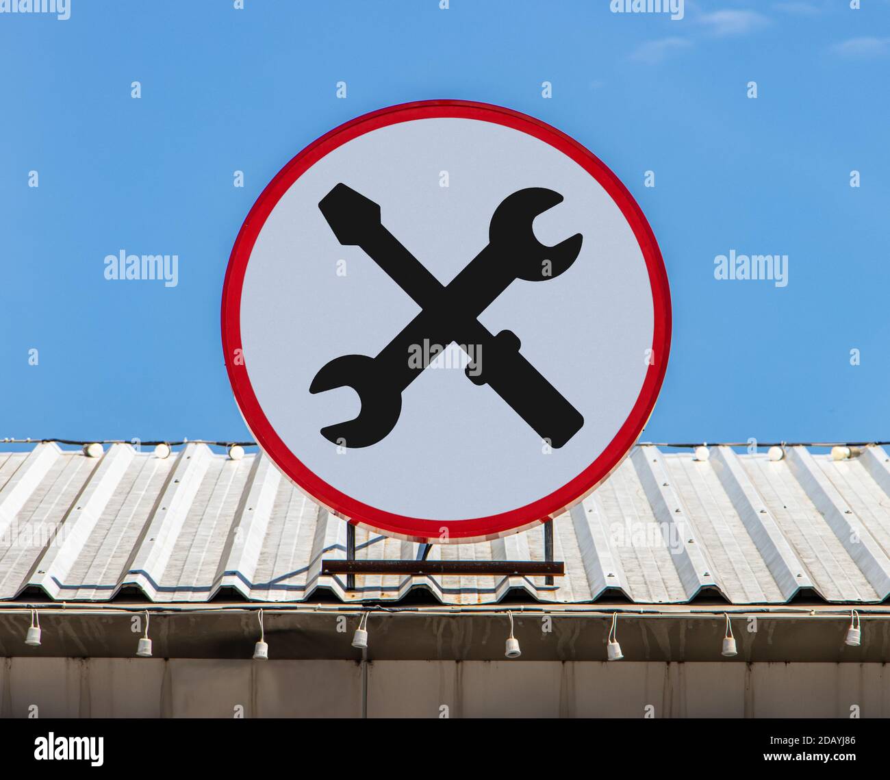 A Circle billboard with icon a tools is installed on a roof. Board of ...