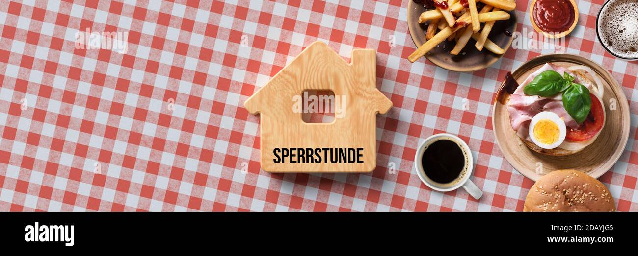 German message for CURFEW on a house symbol with food on kitchen table ...