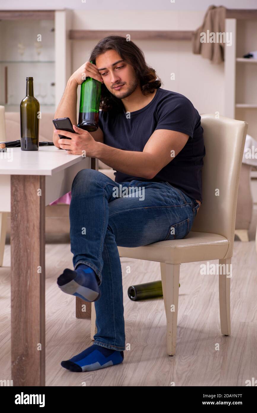 Young man drinking alcohol at home Stock Photo - Alamy