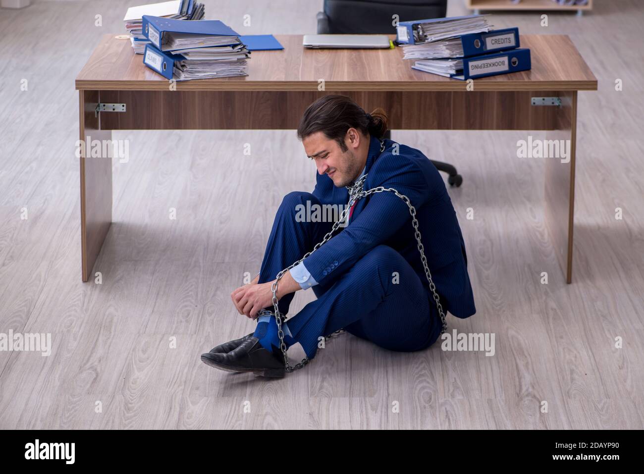 Chained employee unhappy with excessive work in the office Stock Photo ...
