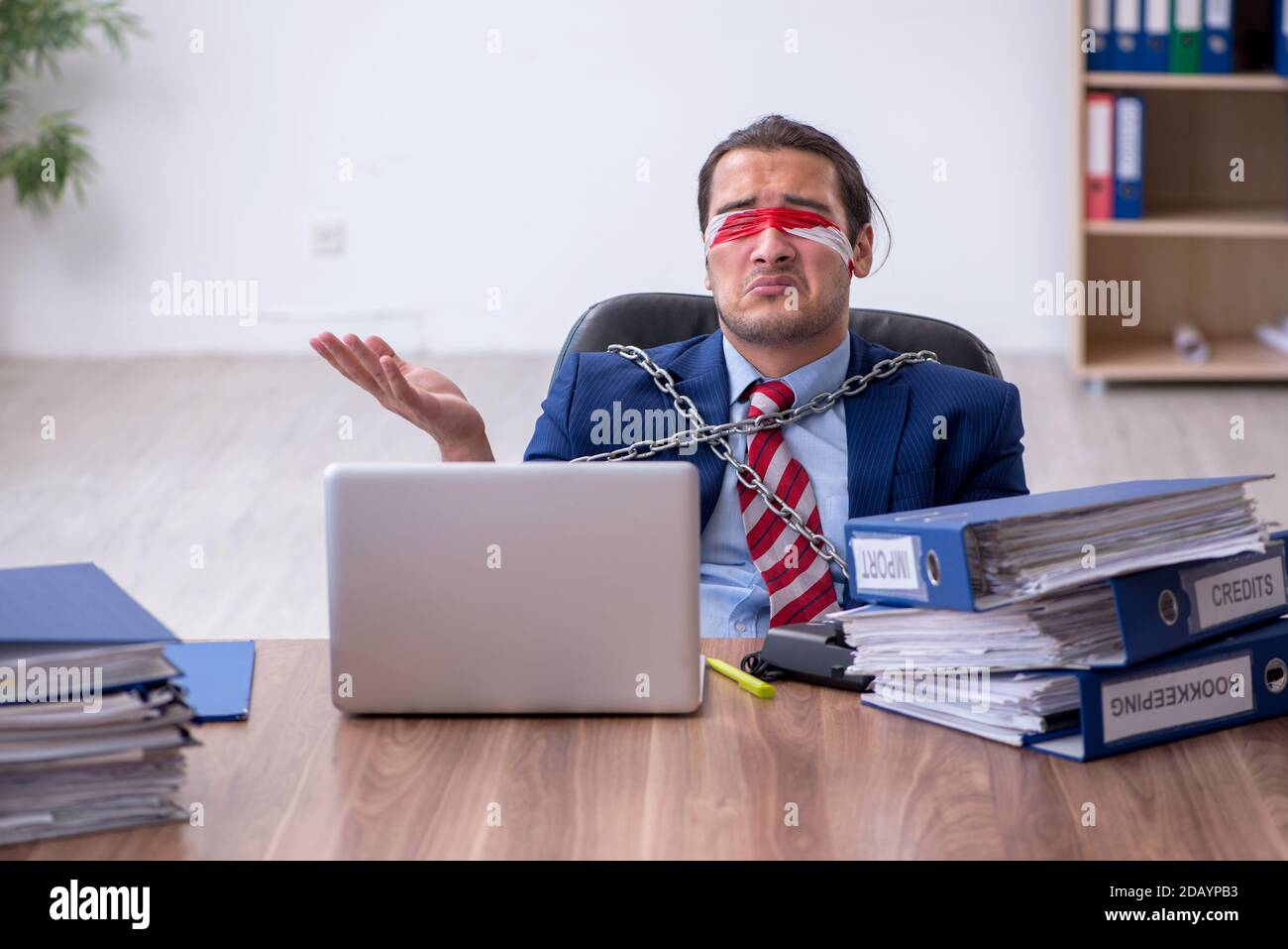 Chained employee unhappy with excessive work in the office Stock Photo ...