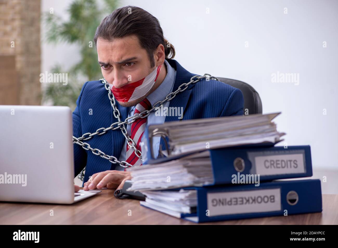 Chained employee unhappy with excessive work in the office Stock Photo ...