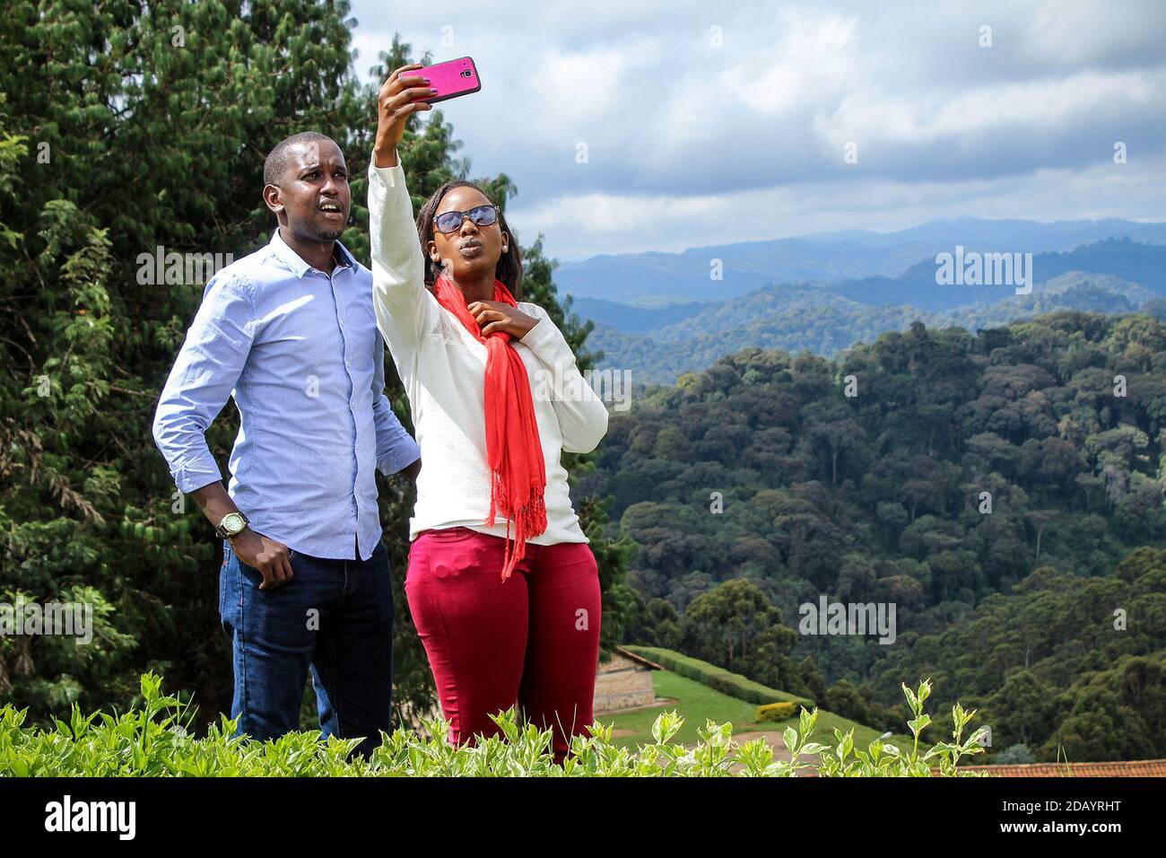Emile Rugambwa (left) and Esther Dusabe take photos at Kitabi Mount ...