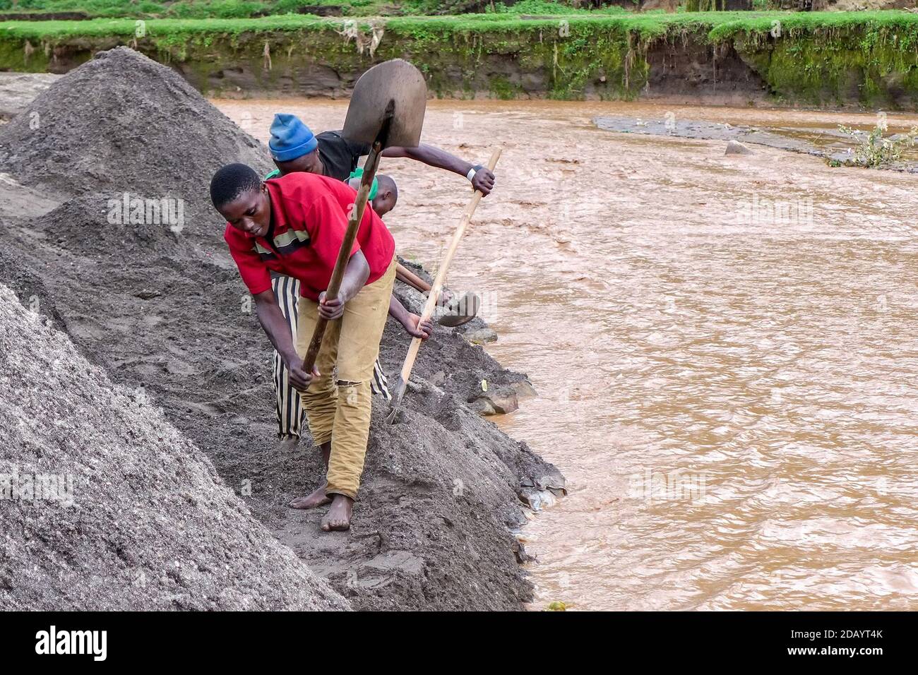 People dig in the mud above an overflowing river in Democratic Republic ...