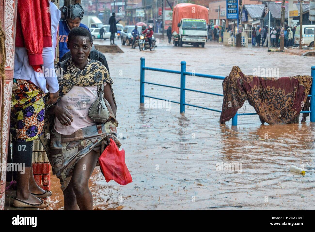 A truck drives through a flooded street in Bwaise, a neighborhood in ...