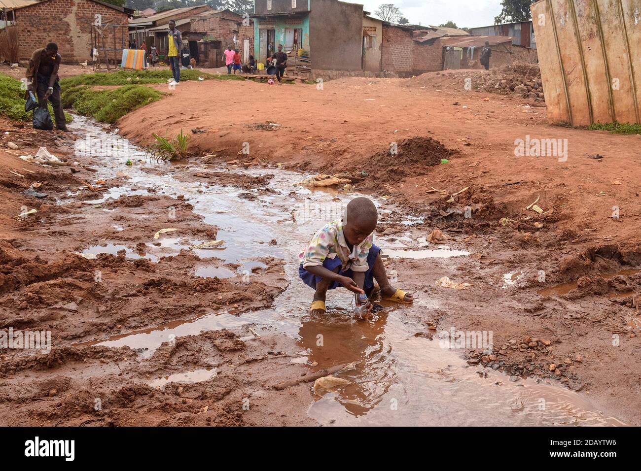 Children in in Kabowa, a village in west Kampala, play in puddles Stock ...