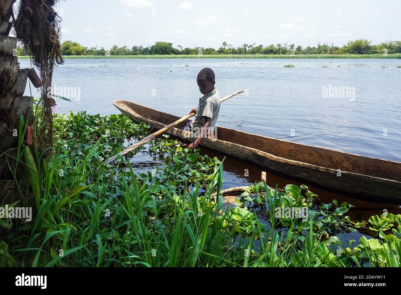 A young boy goes fishing in a canoe on the Tshopo River in Kisangani ...
