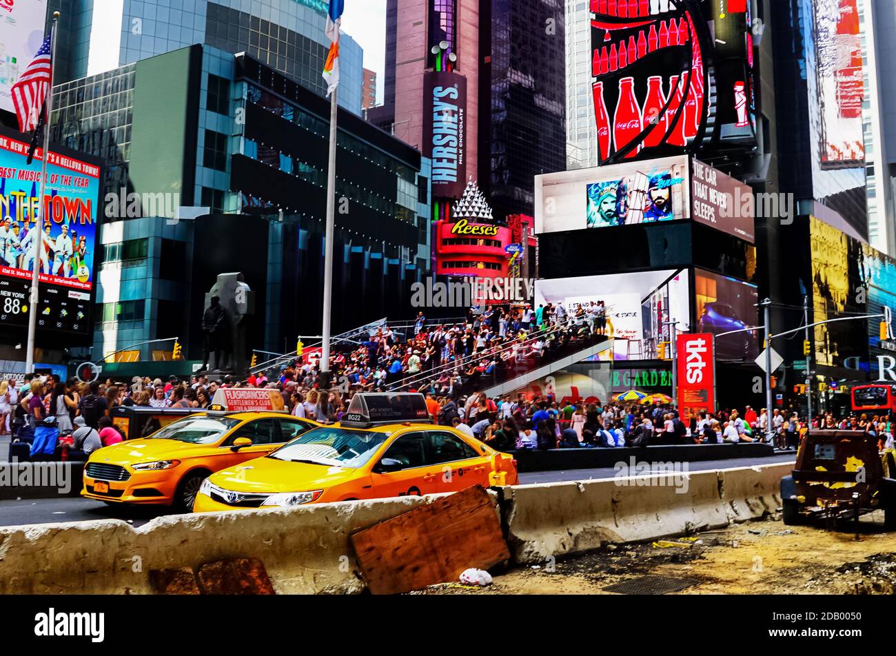 Times Square with yellow New York City Taxi cabs and tour buses driving ...