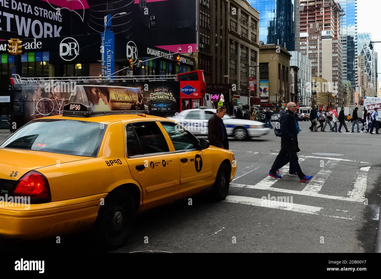 Times Square with yellow New York City Taxi cabs and tour buses driving ...