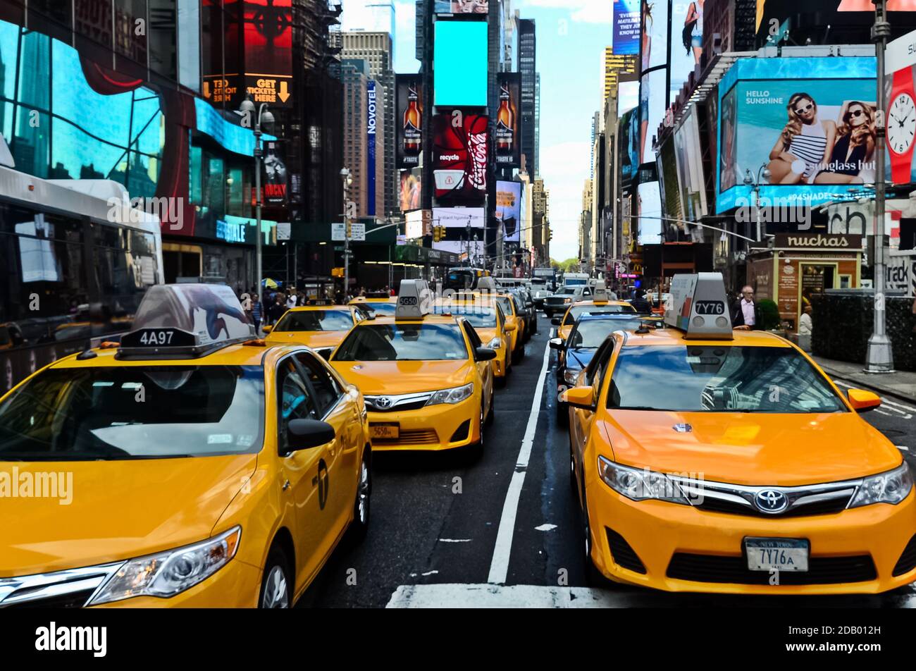 Times Square with yellow New York City Taxi cabs and tour buses driving ...