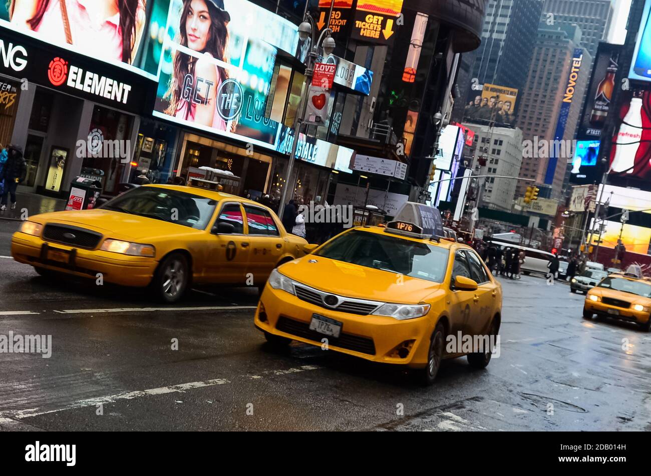 Times Square with yellow New York City Taxi cabs and tour buses driving ...