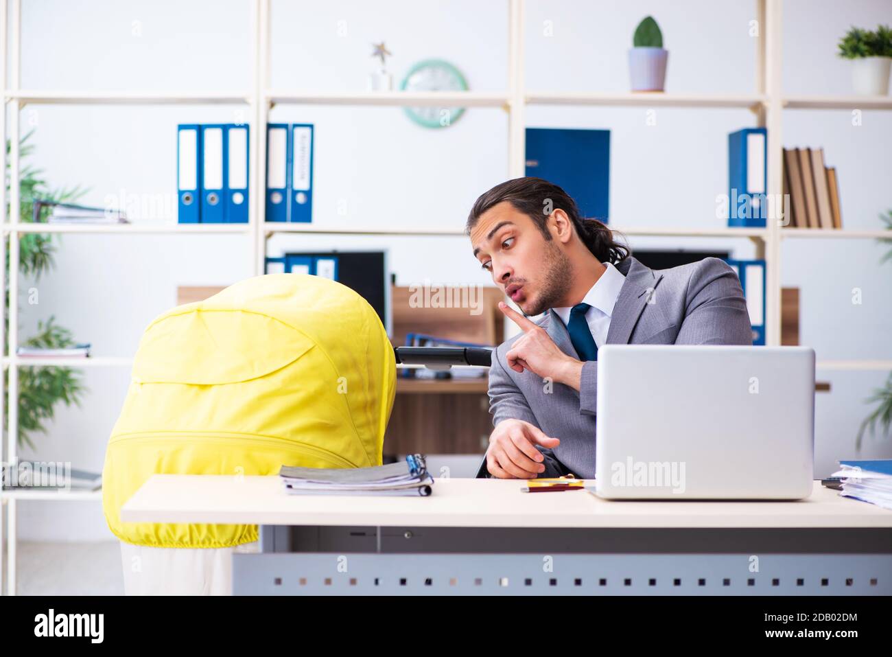 Male employee looking after newborn at workplace Stock Photo - Alamy