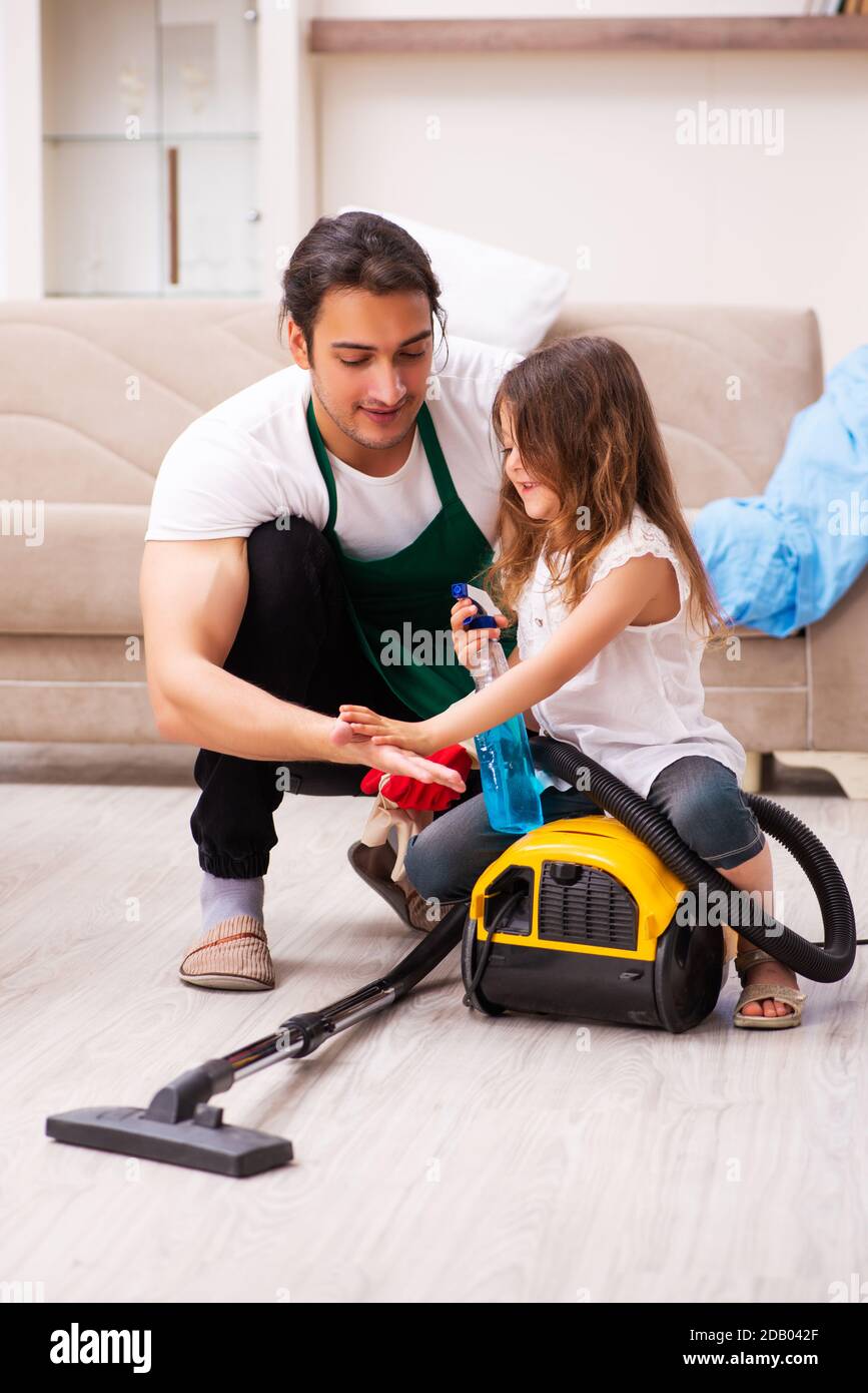 Young contractor cleaning the house with his small daughter Stock Photo ...