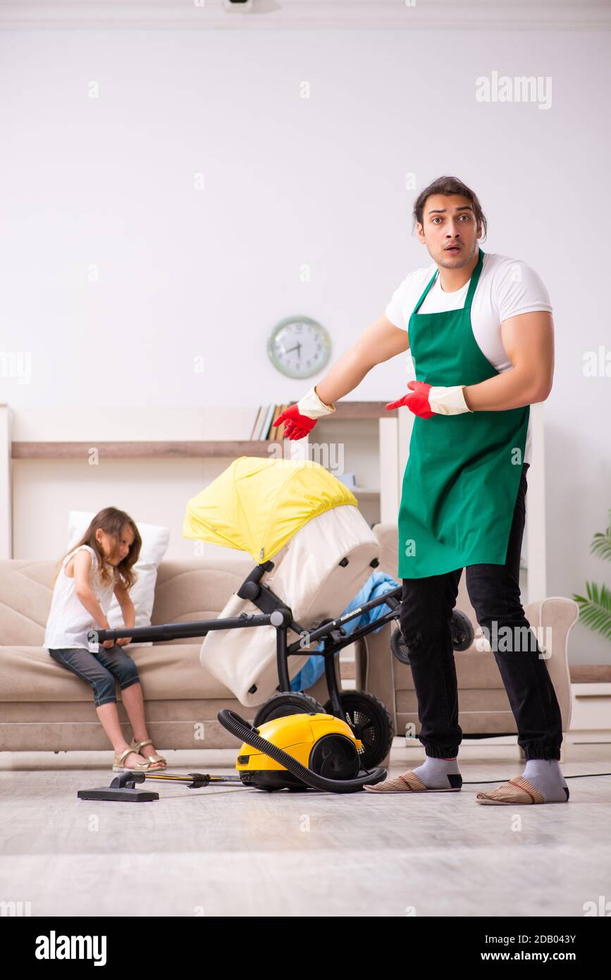 Young contractor cleaning the house with his small daughter Stock Photo ...