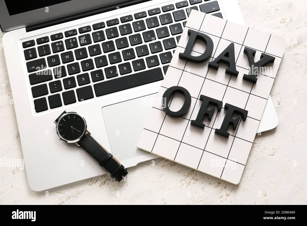 Laptop with watch and notebook with text DAY OFF at workplace Stock ...