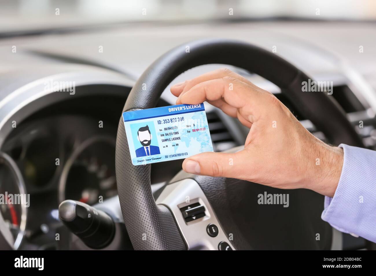 Man with driving license in car salon Stock Photo - Alamy