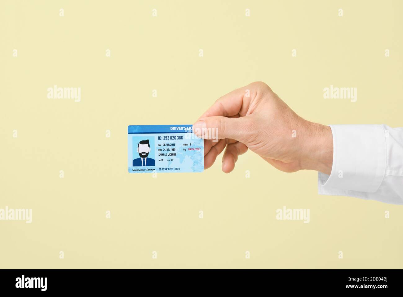 Male hand with driving license on color background Stock Photo - Alamy