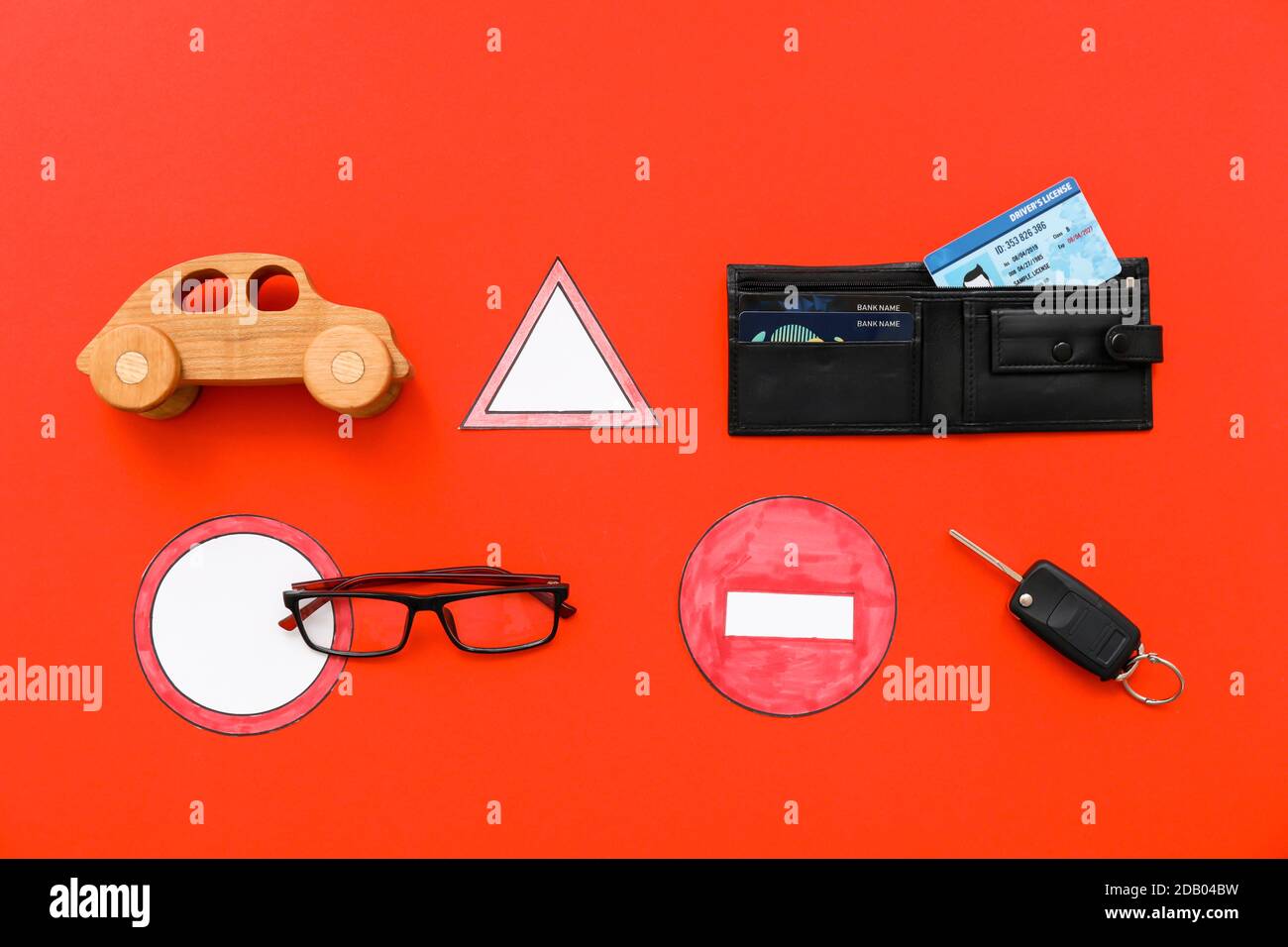 Driving license with wallet, car, key and road signs on color ...